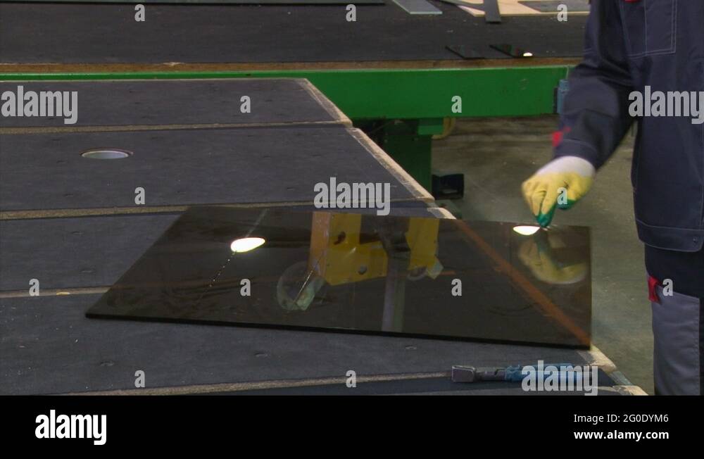 Cracking glass by worker hands on cutting table, window glass ...