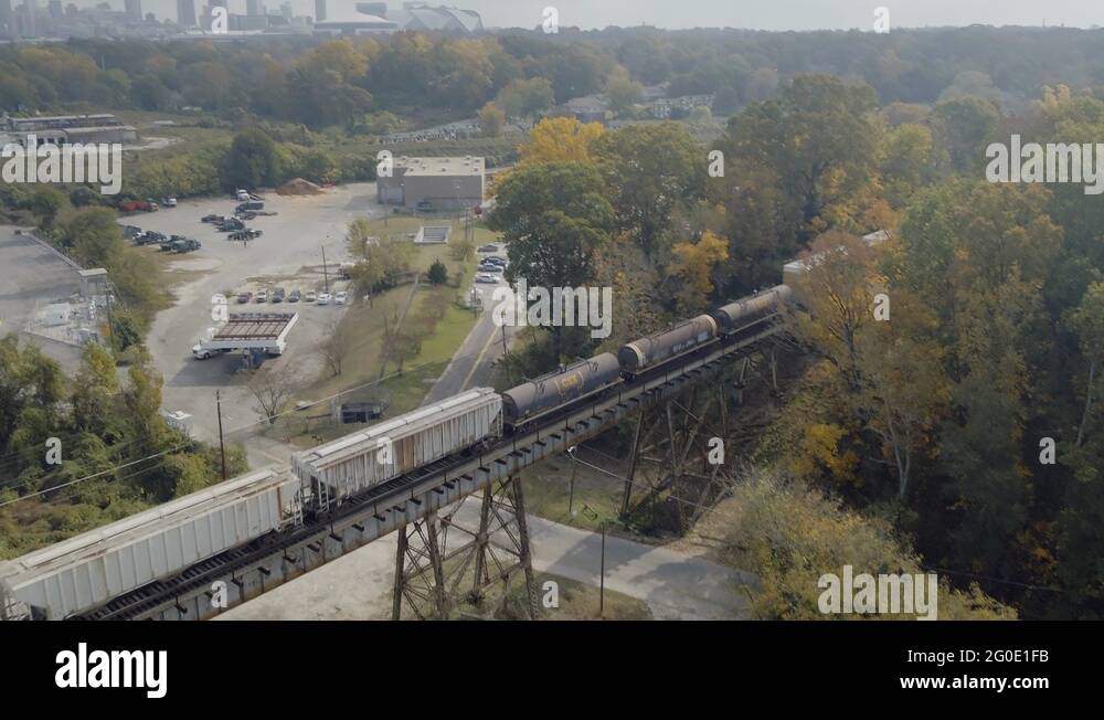 Fly along moving train over railroad bridge to tilt up to Atlanta ...