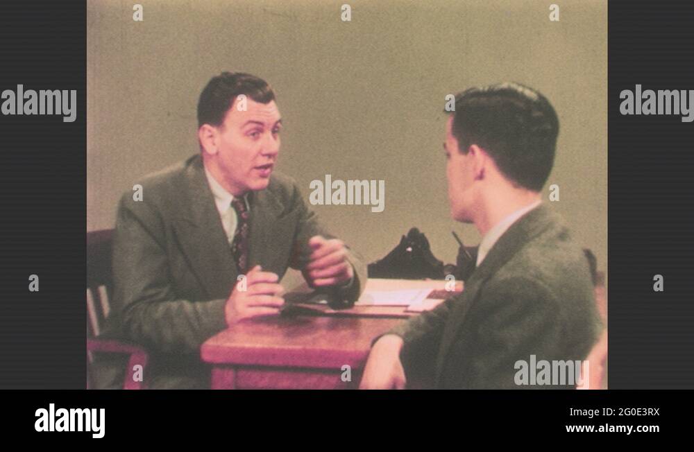 1950s: Interviewer explains to applicant. Applicant listens with ...