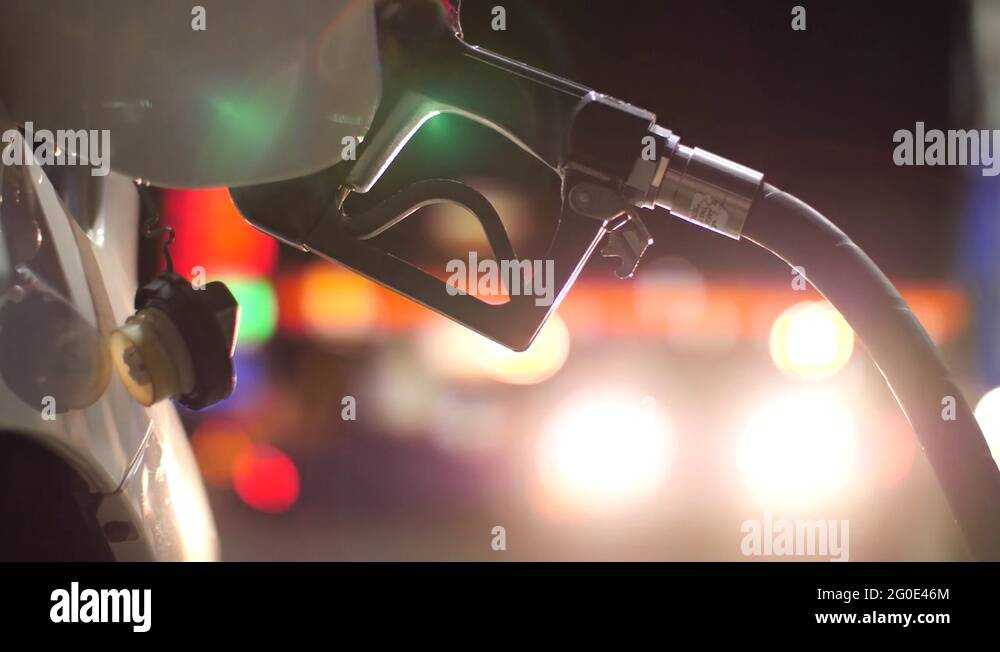 Fuel nozzle inserted in car's gas tank as it's being refueled gas ...