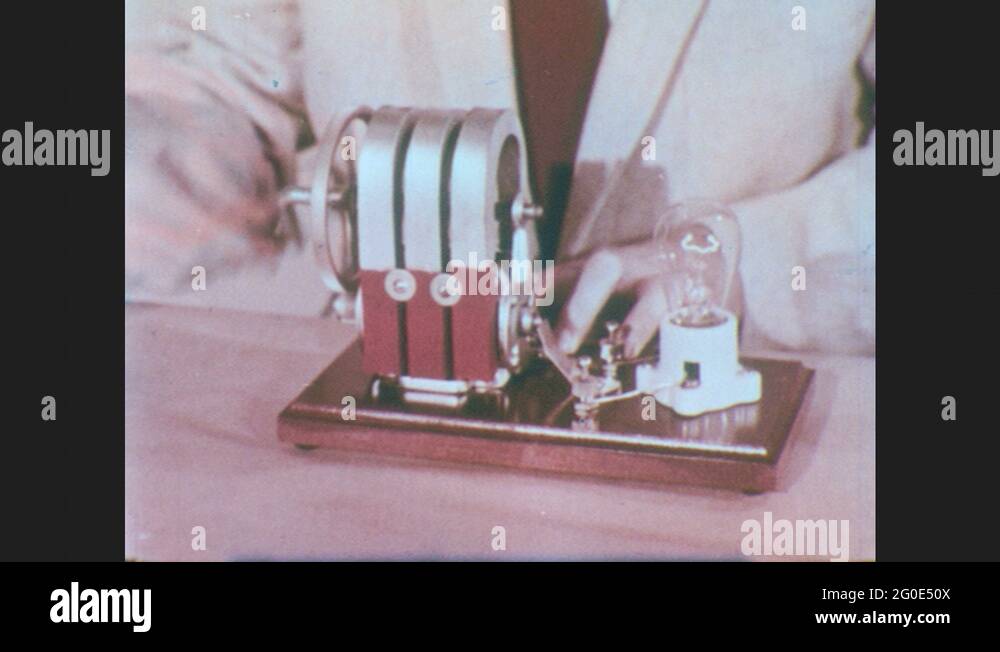 1950s: UNITED STATES: hand turns generator crank. Light bulb lights up ...