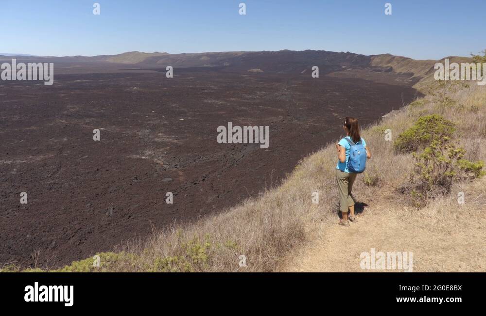 Galapagos tourist hiking on volcano Sierra Negra Volcano Crater ...