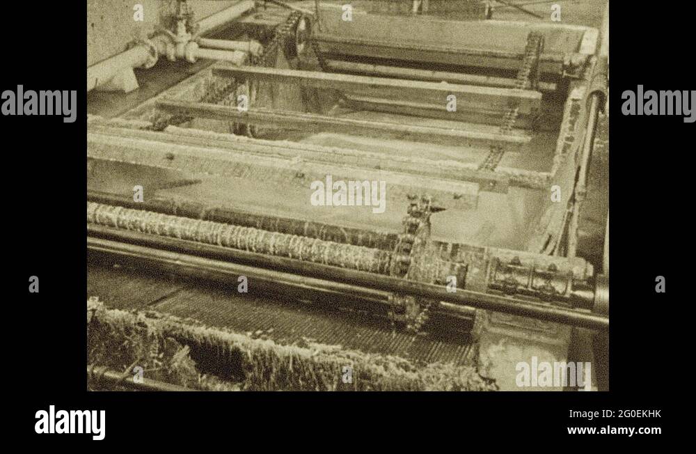 1920s: UNITED STATES: machine turns wood pulp at mill. Water mixes with ...