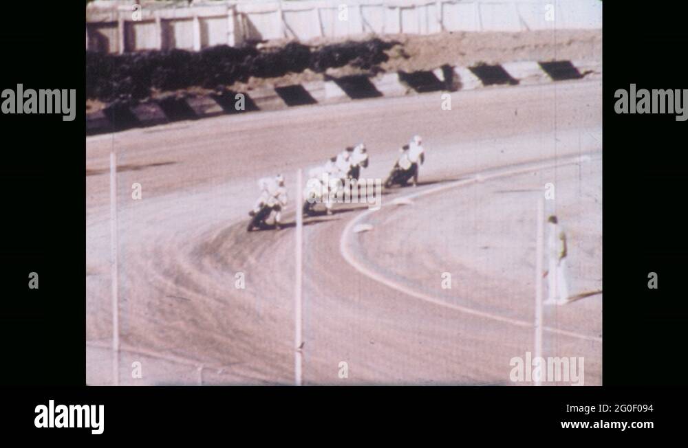 1970s: UNITED STATES: bikes race around circuit at track. Honda advert ...