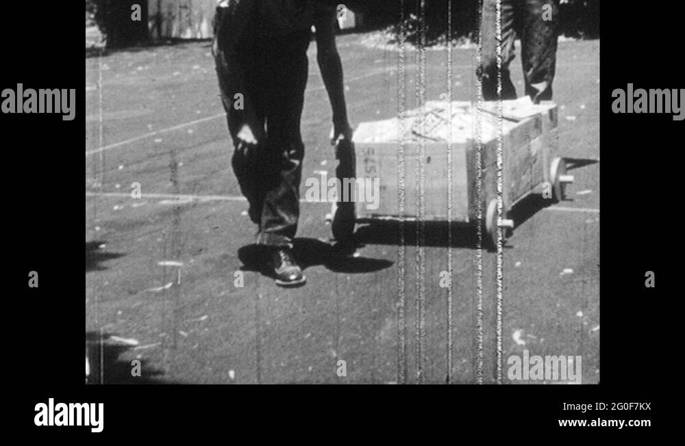 1950s: Boys pull box of comics across pavement using wooden wheels ...