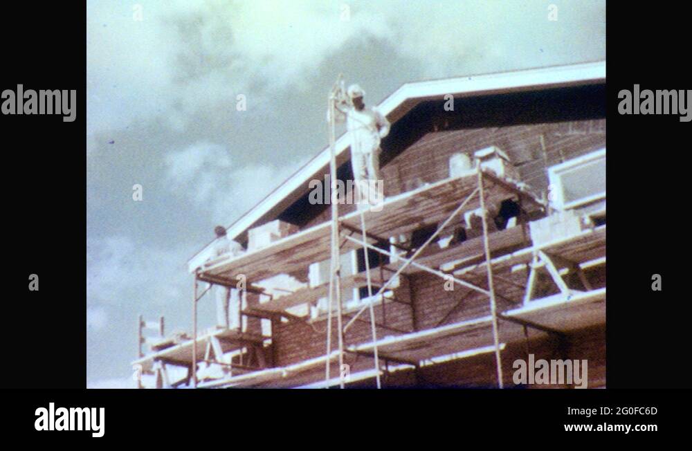 1960s: Construction workers stand on scaffolding in a house ...