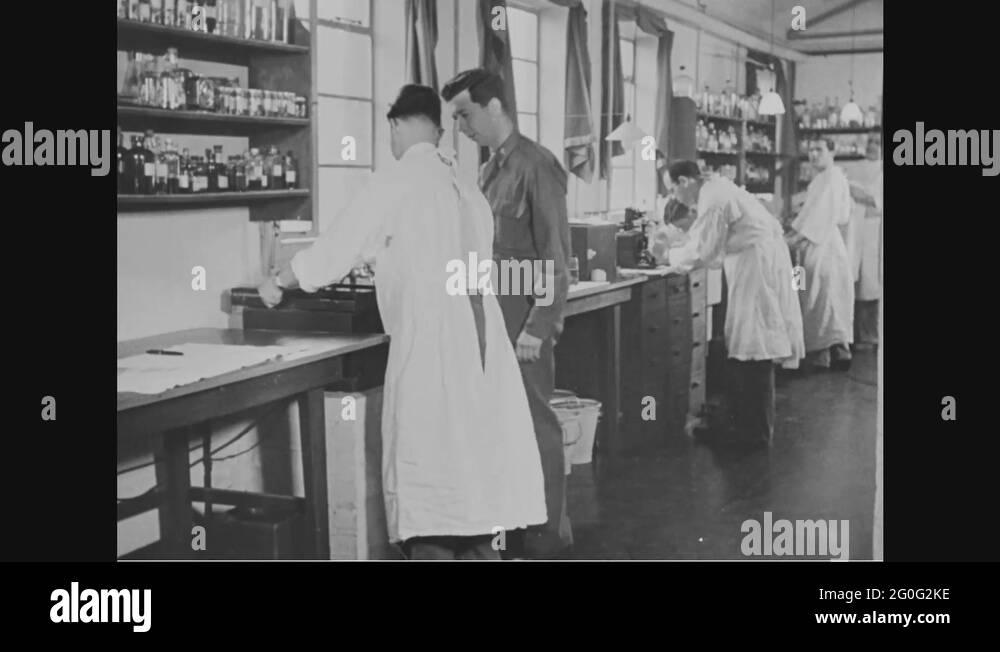 Technicians at general hospital look under microscope to study the ...