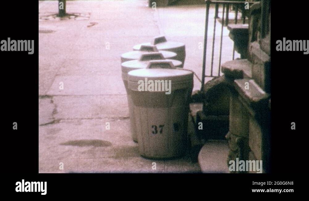 1970s: Plastic garbage bins on side of road. Trash cans next to stairs ...