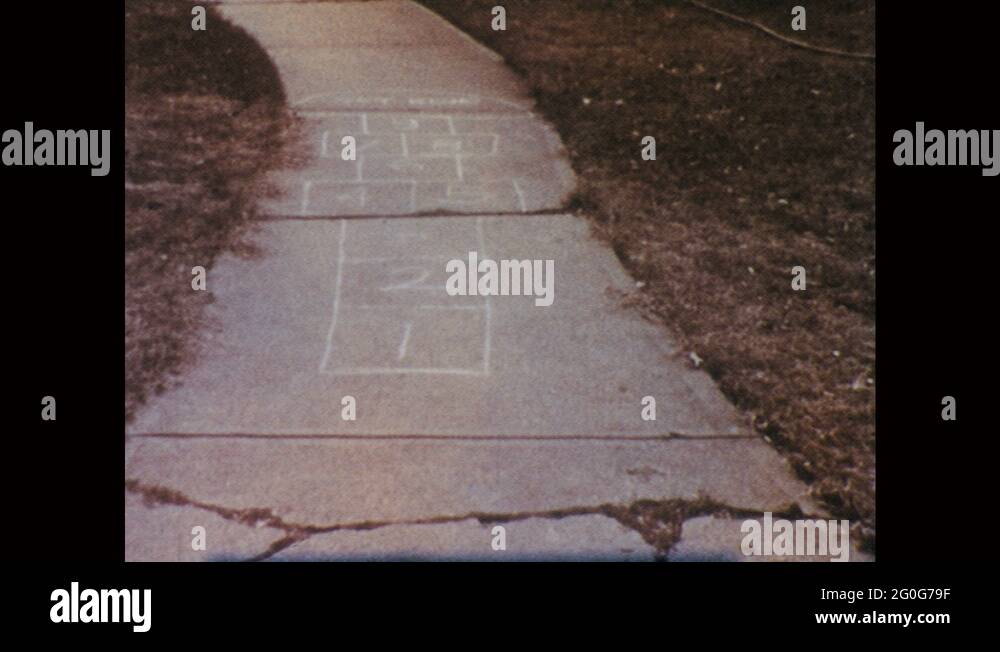1950s: Hopscotch court on sidewalk. Young girl completes hopscotch ...