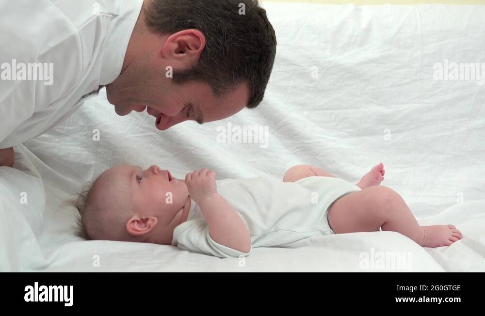 Father and baby child talk, building relationship, newborn lying down ...