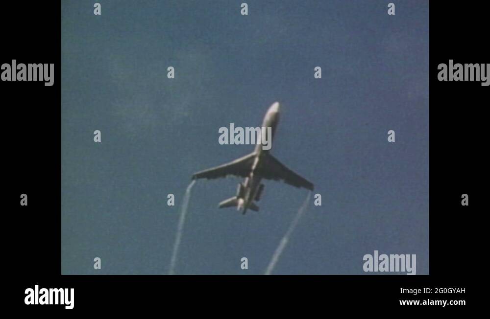 1970s: Jetliner flies as smoke streams from wings. Wing of jetliner in ...