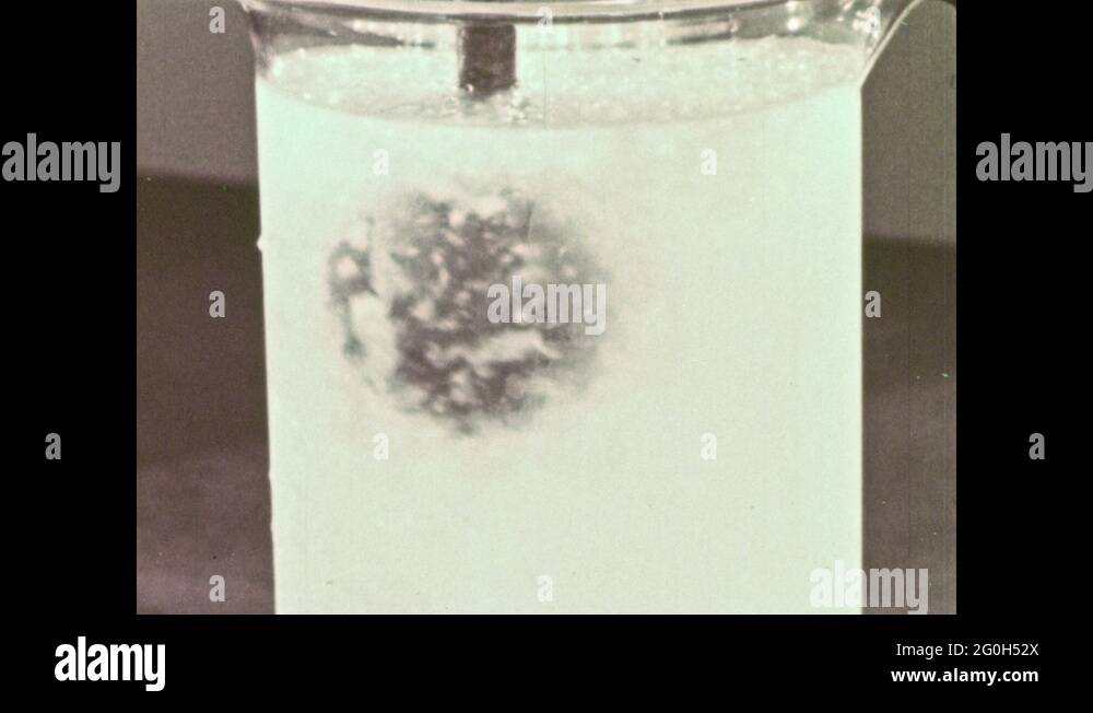 1960s: Metal container in beaker of liquid, container explodes Stock ...