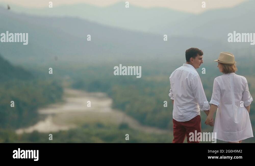 Close-up back view from drone on the cheerful kissing couple at the ...