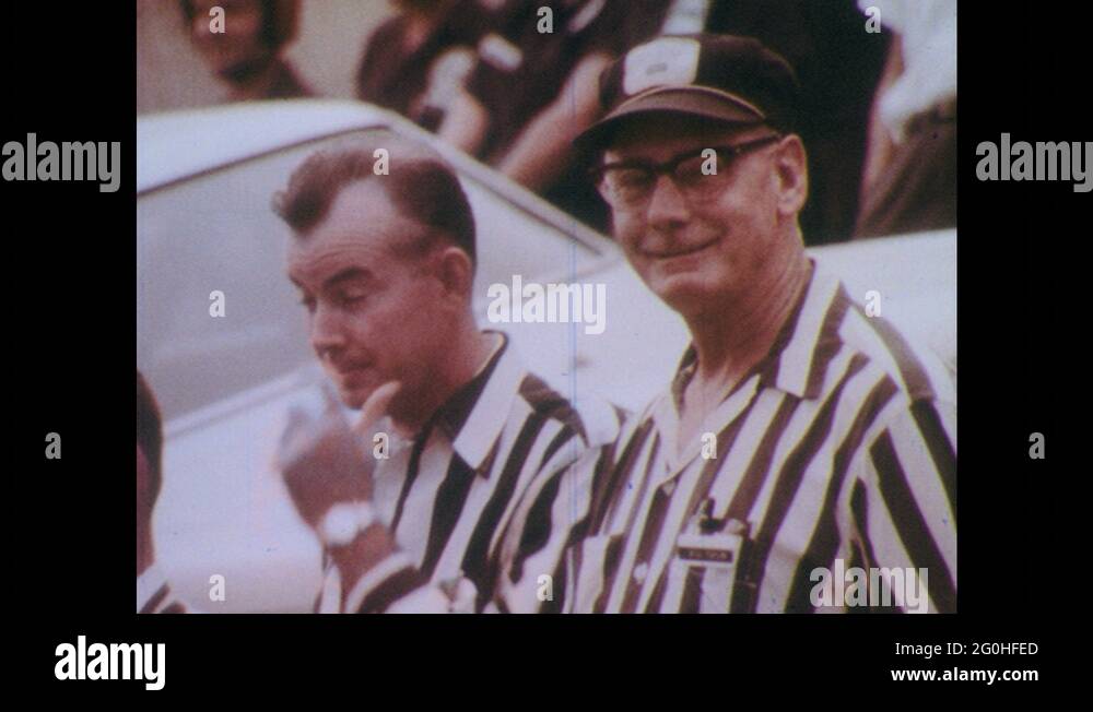 1960s: UNITED STATES: crew line up by grandstand. Men watch race. World ...