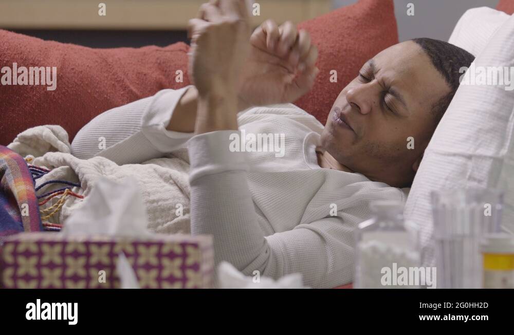 Man tossing and turning on the sofa with cold and fever pain Stock ...