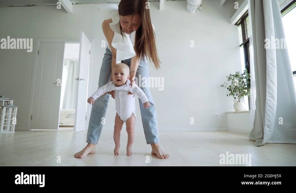Young mom teaches son to walk holding hands Stock Video Footage - Alamy