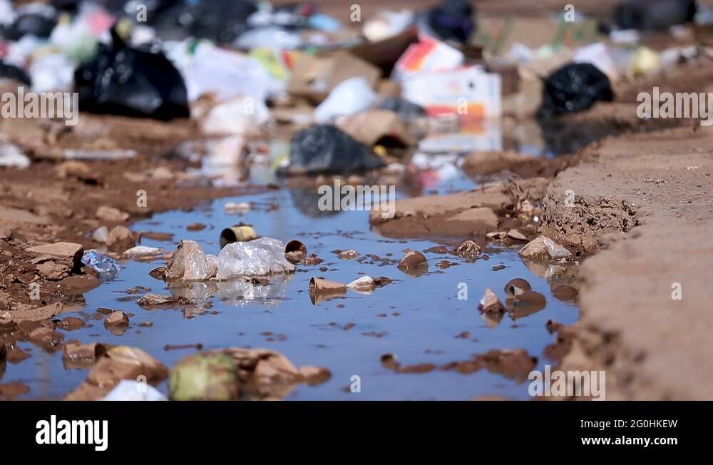 Piles of garbage sit in a ditch on a roadside Stock Video Footage - Alamy