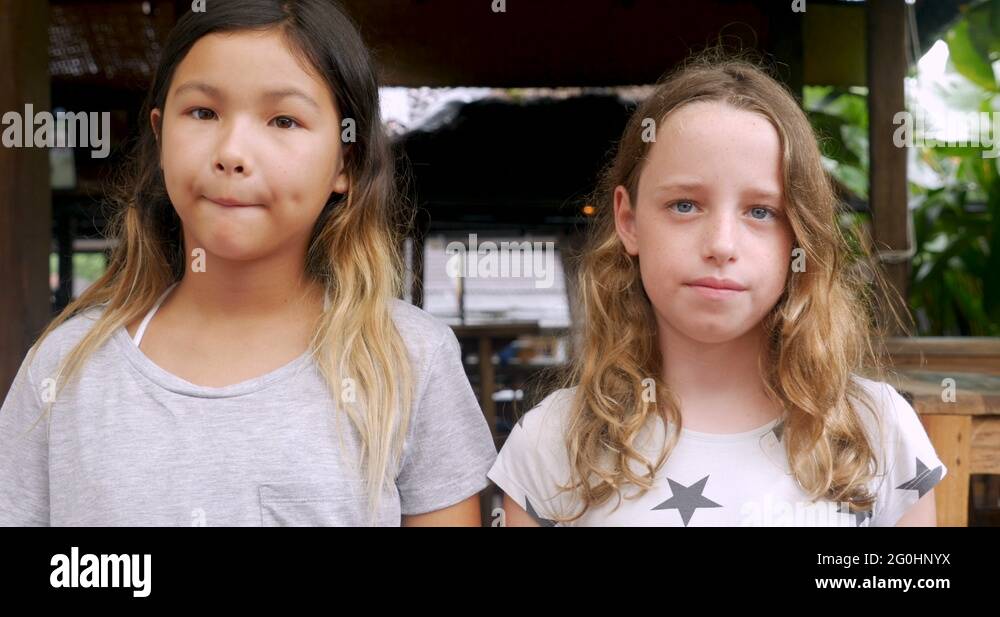 Two shy awkward young girls standing next to each other waiting Stock ...