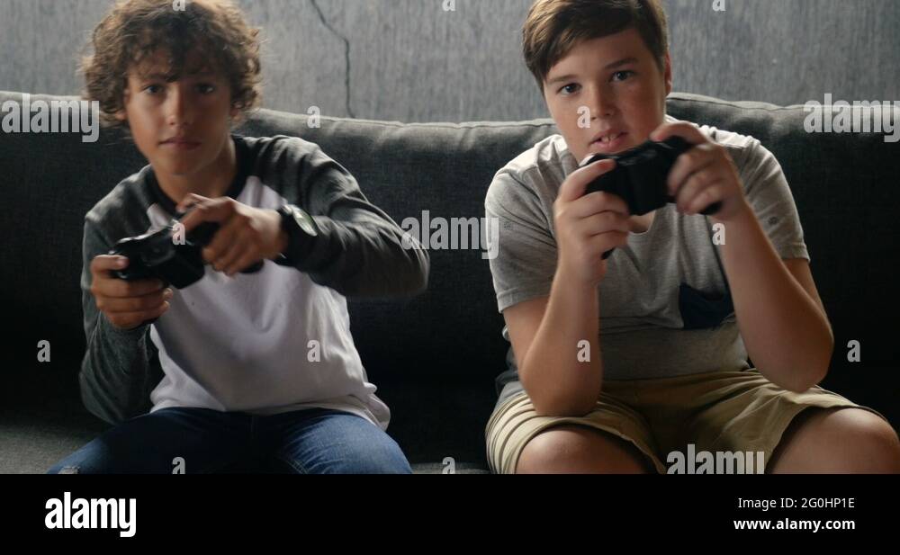 Two young boys playing video games together and getting to the finish ...