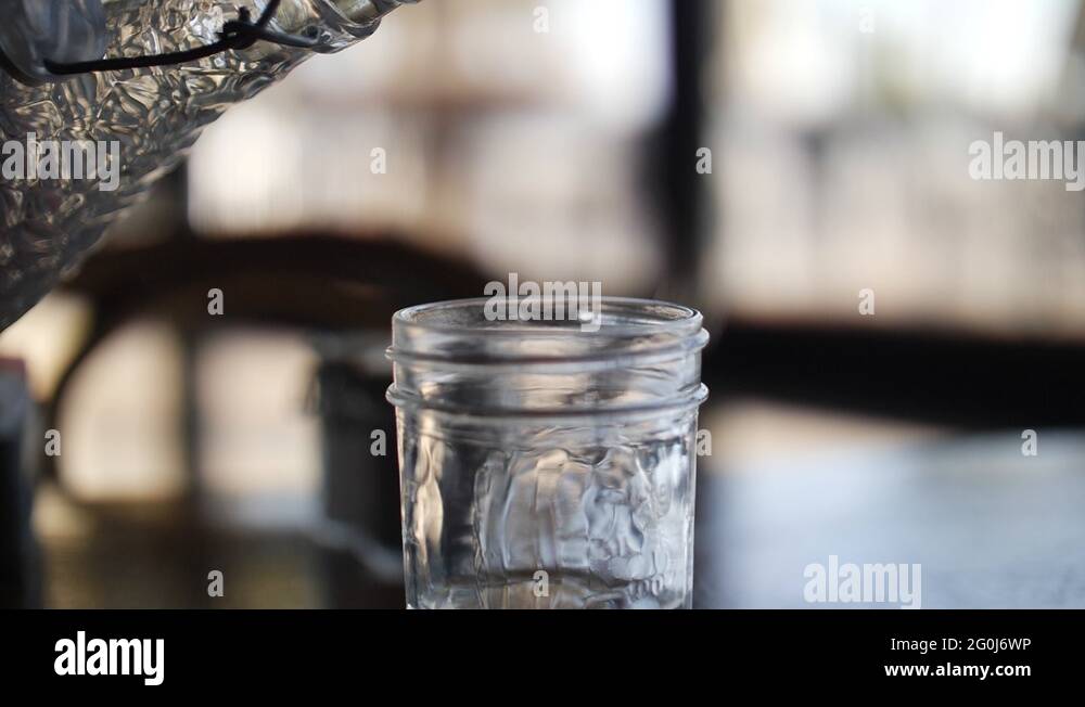 Pouring water into glass from decorative bottle Stock Video Footage - Alamy