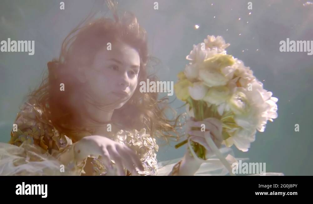 young woman with long red hair underwater like in a fairy tale floats ...