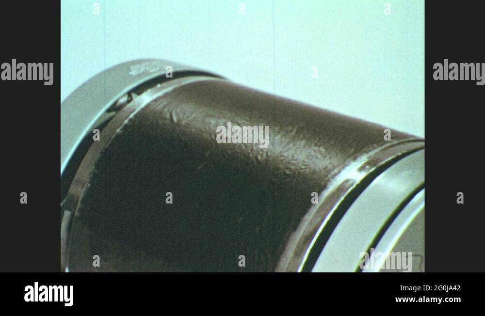 1950s: Close up, roller on copier, hands lay stencil on copier. Hands ...