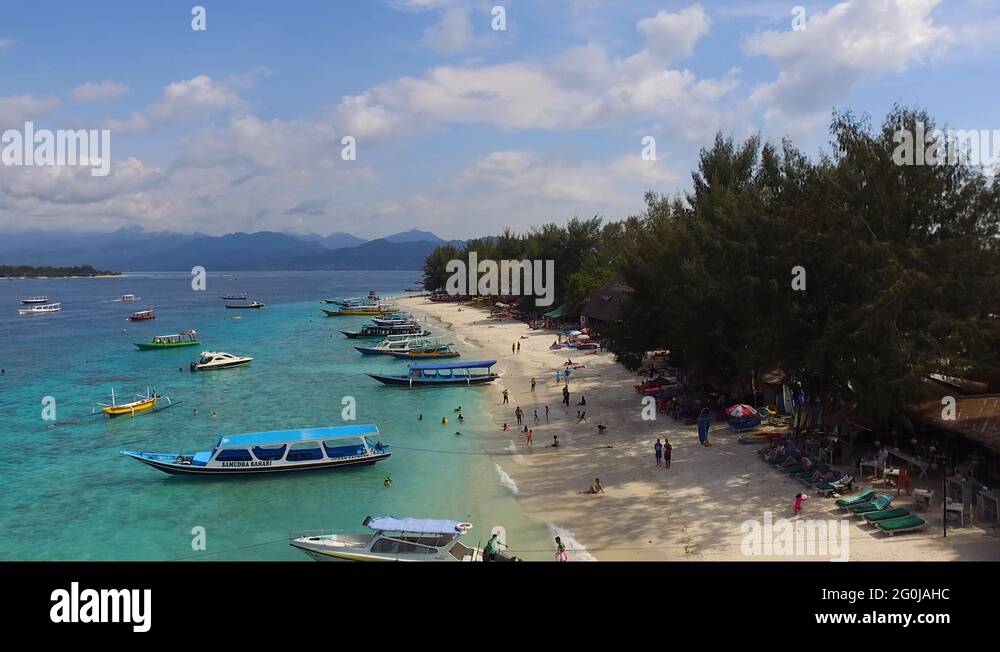 Cinematic aerial of busy beach in the island of Gili Trawangan in Bali ...