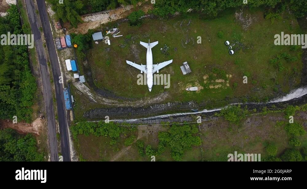 Birds eye view of air plane in a scrapyard in the middle of rain forest ...