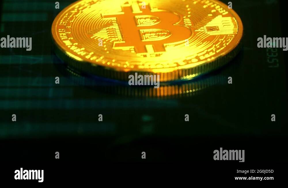 Gold coin bitcoin, lying on the screen with a picture of the graph of ...
