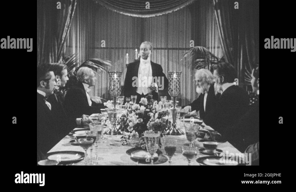 1950s: Man stands speaking at head of long banquet table of men Stock ...