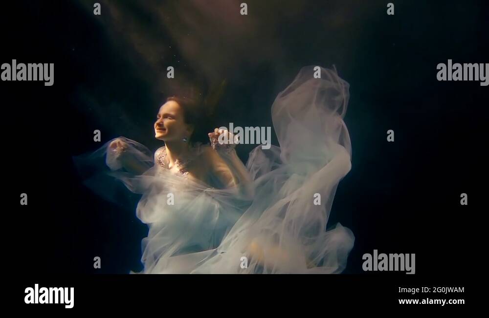 cute girl is floating at the depth of the sea, the lady is looking at a ...