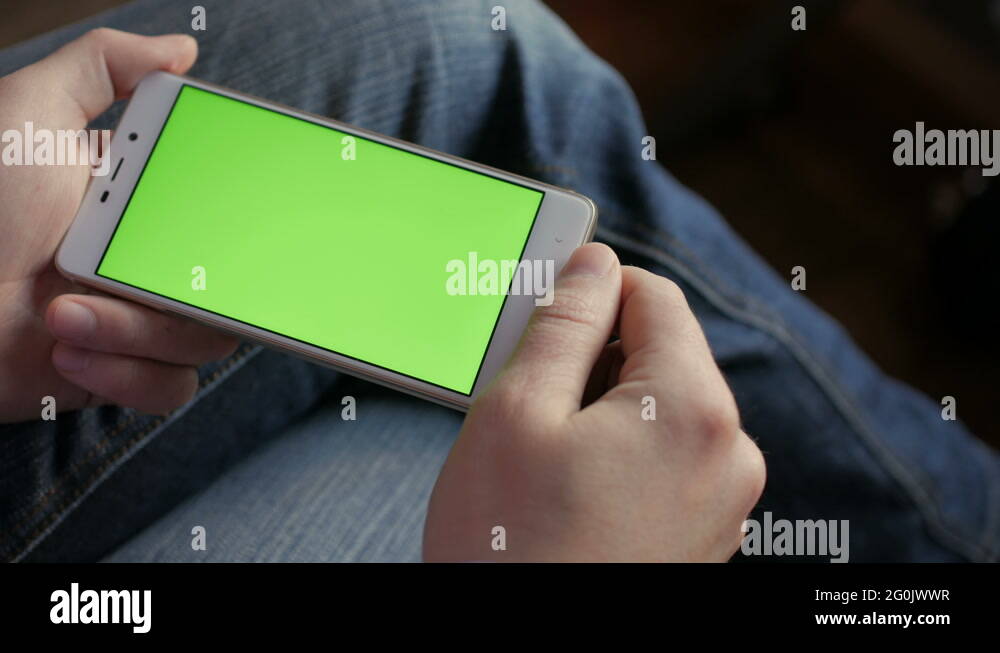 Man in the workplace using his smartphone with green screen, scrolling news Stock Video Footage ...