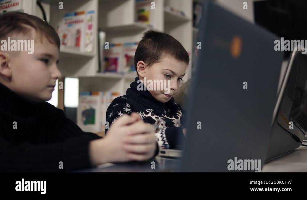 Little boy is trying to type something on laptop keyboard. Learning how ...