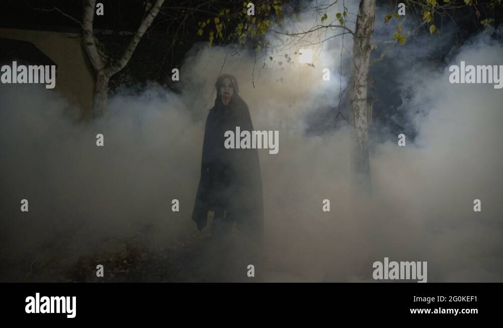 Zombie female vampire smiling maleficent and walking among trees on ...