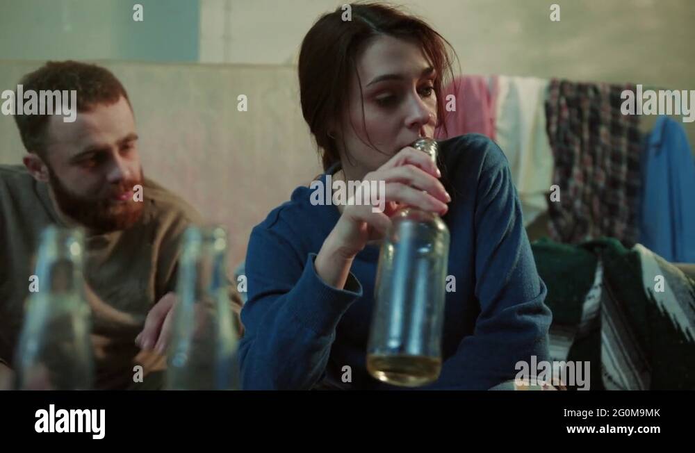 Drunk young poor couple drink beer sit on sofa stress unhealthy ...