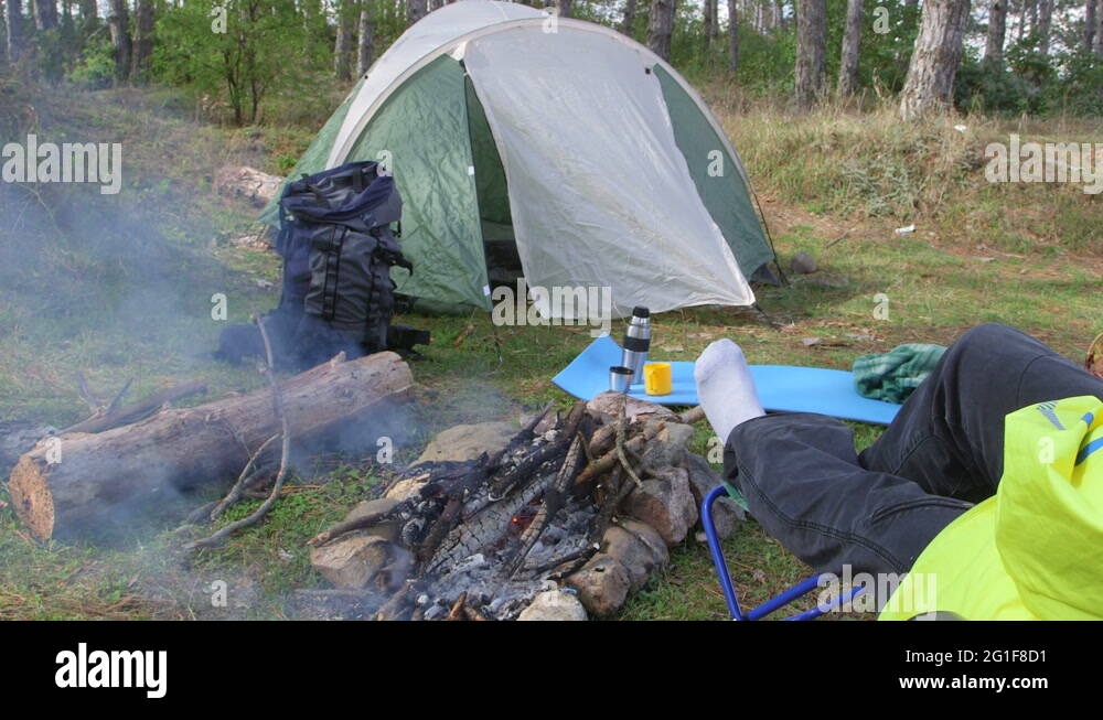 Camping woman resting by campfire Stock Video Footage - Alamy