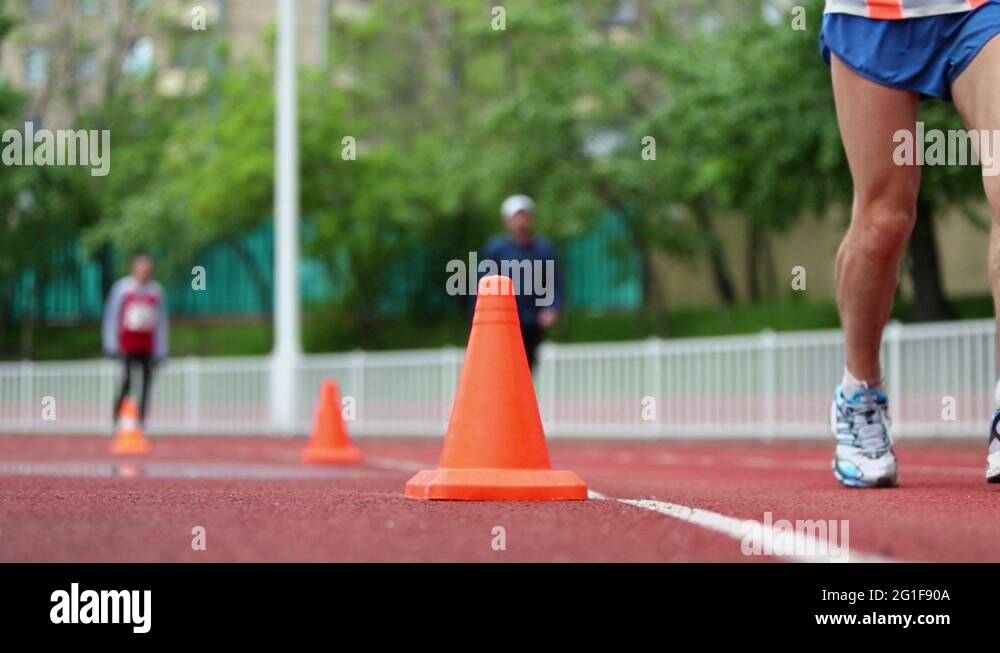 Running track at stadium with runners, focus on cone Stock Video ...