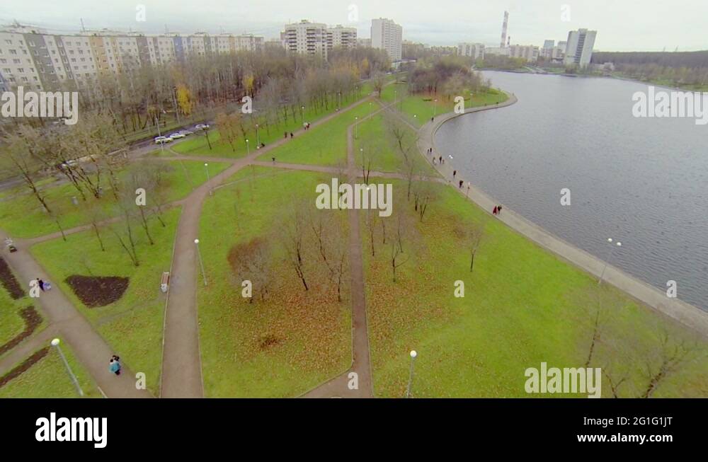 Kids play on playground and people walk by paths in park Stock Video ...