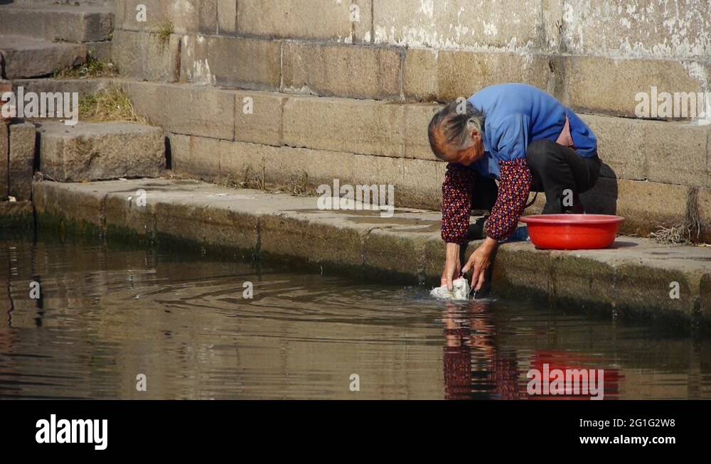 chinese old woman wash cloths under bridge,china water town life Stock ...