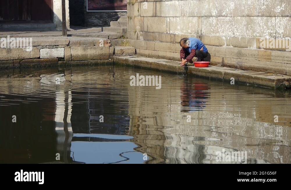 chinese old woman wash cloths under bridge,china water town life Stock ...