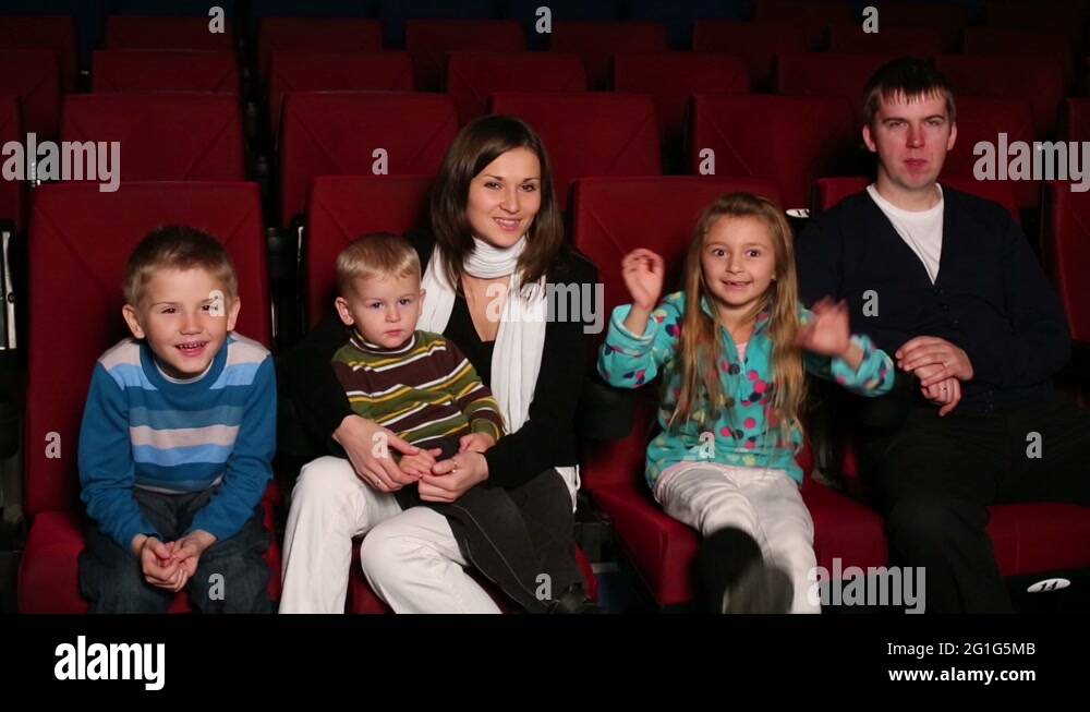 family sitting on the front row of auditorium at cinema Stock Video ...