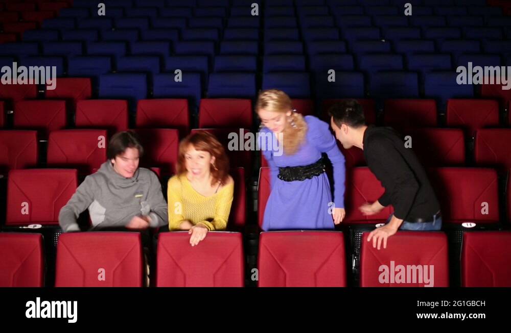 Young people sit on their seats in dark hall cinema Stock Video Footage ...