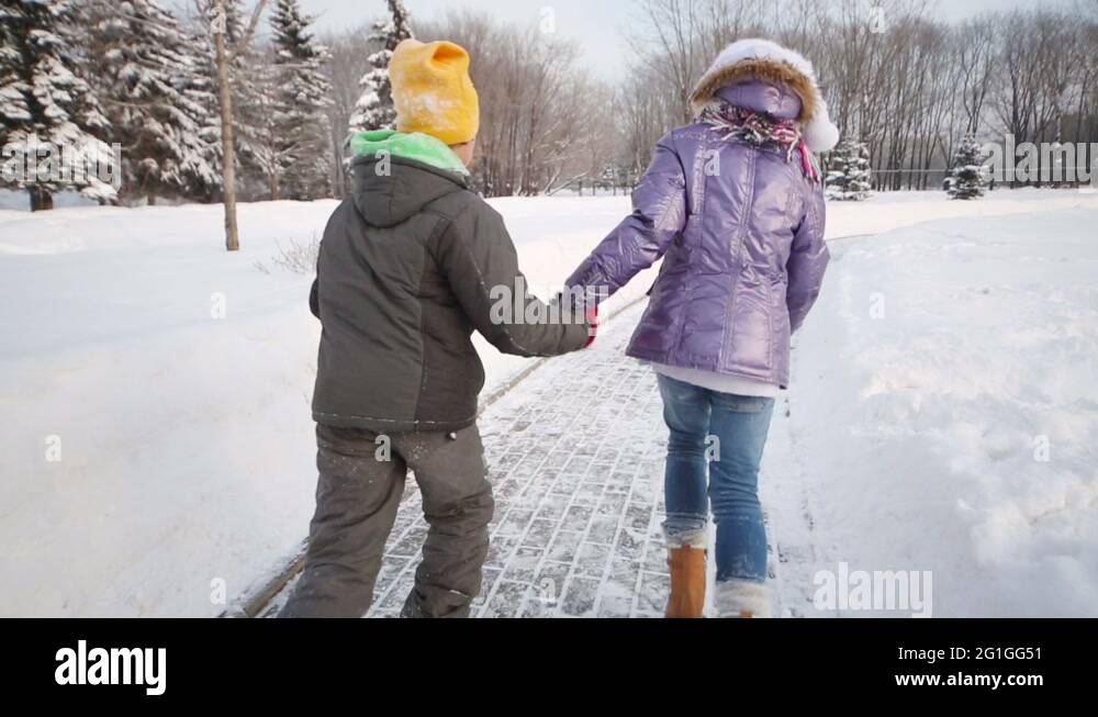 Back of brother and sister running on pathway in park Stock Video ...