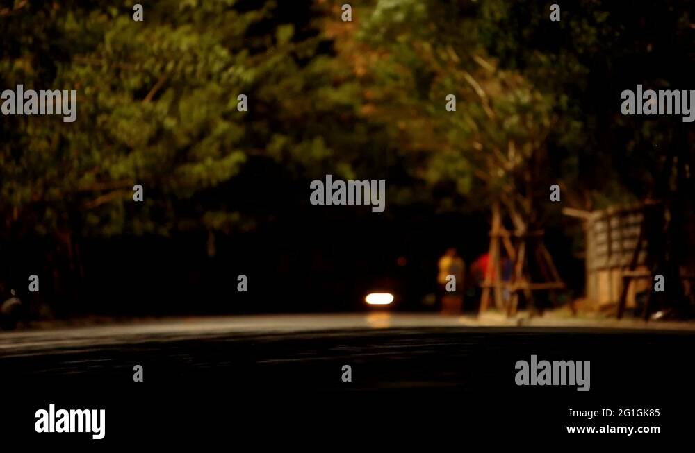 Night traffic with a slow shutter speed and crowd of people walking on ...