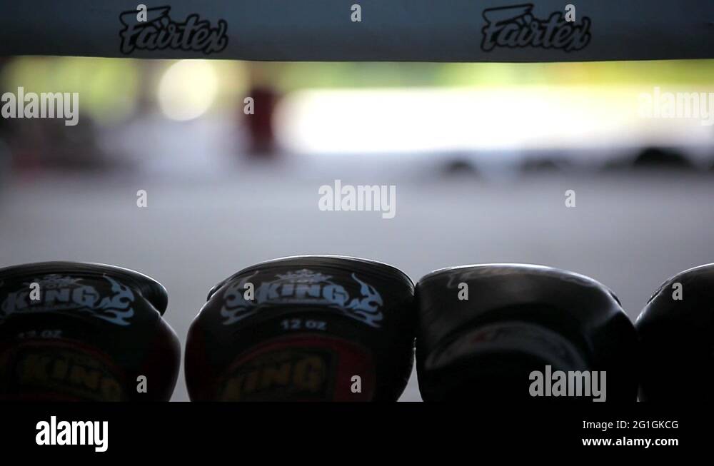 boxing rubber gloves lie at the arena in a row on blurred background ...