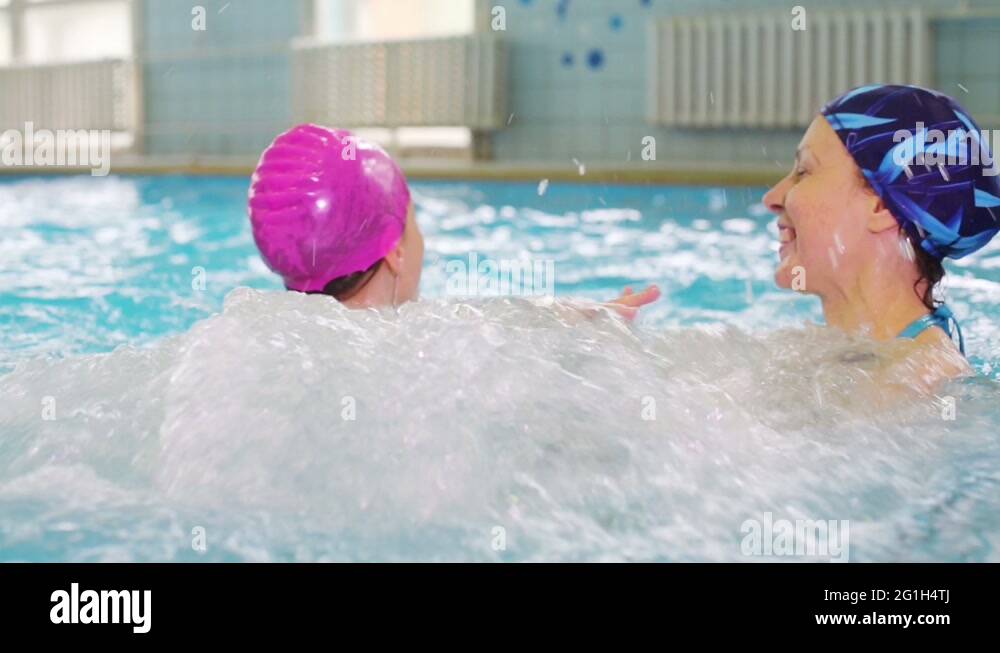 Mother and happy daughter swim in pool with waterfall jet Stock Video ...