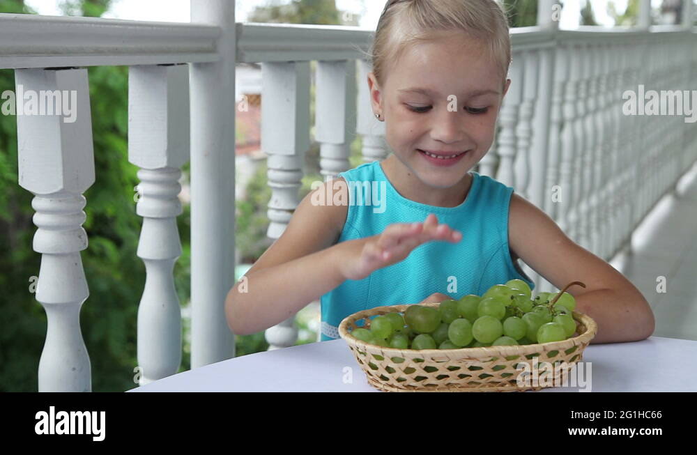 Child playing in the Kids Count and eating grapes. Child shows Ok ...