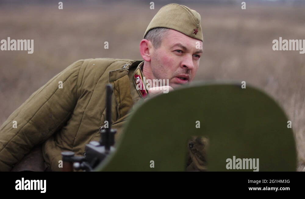 Soviet soldier taking aim for a machine gun Maxim. WW2 reconstruction ...