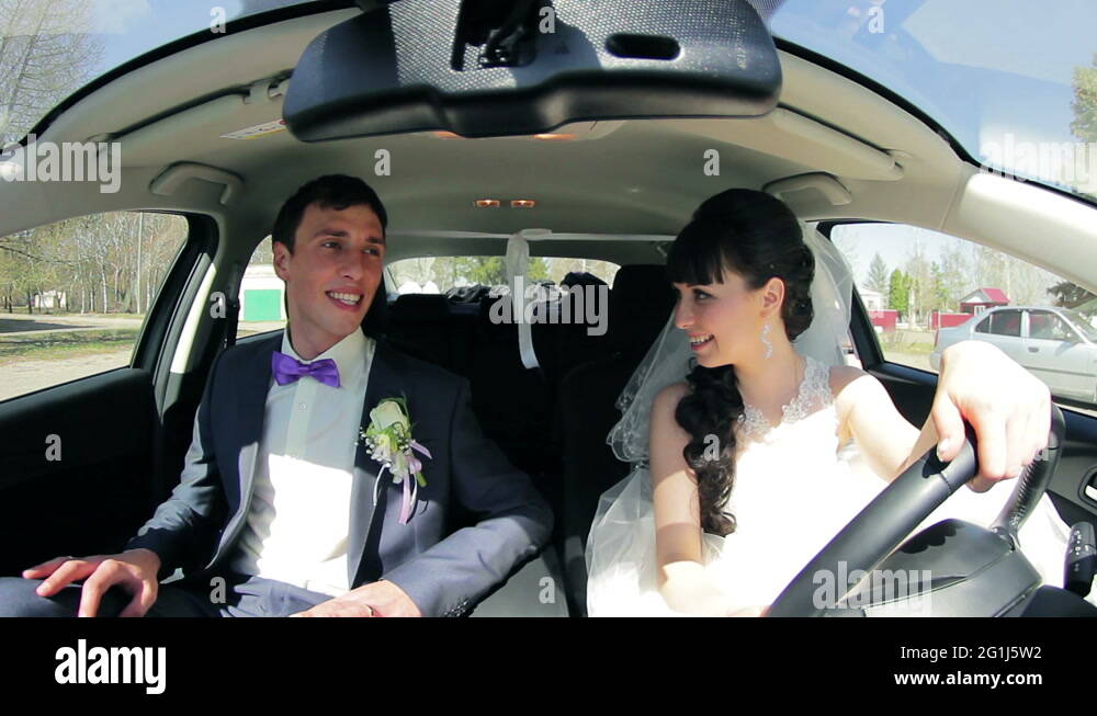 The bride and groom have fun behind the wheel of car. Wedding. video HD ...
