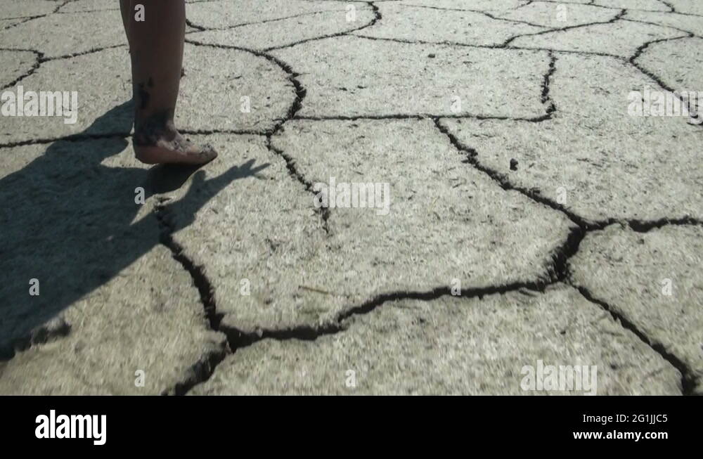Child To Walk Barefoot On Cracked Dry Ground Stock Video Footage - Alamy